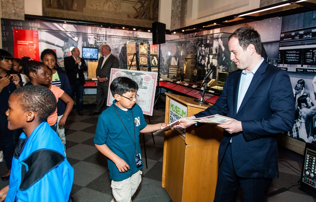 Alexander Burns hands out stock certificates to students at the launch ...